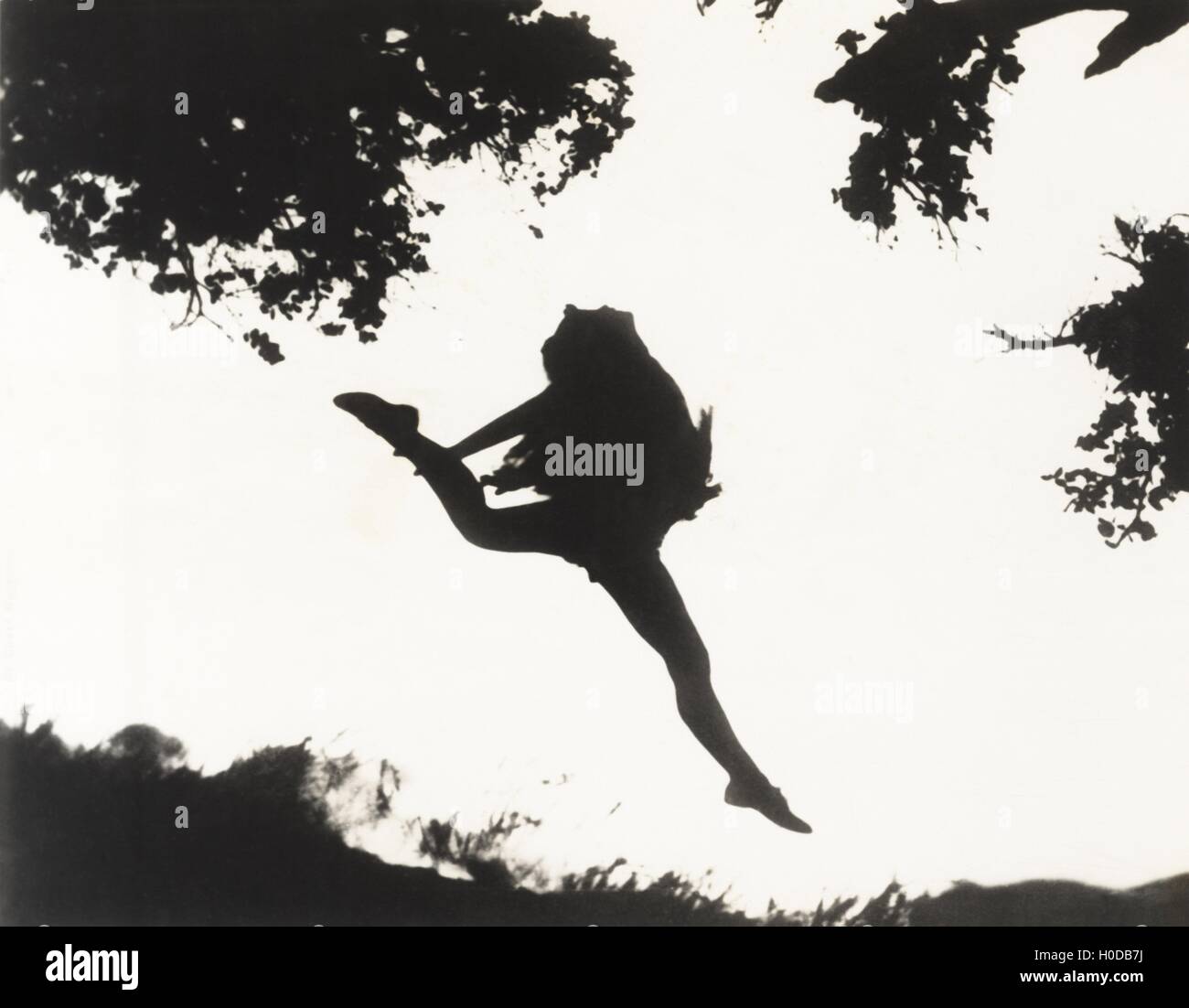Silhouette of woman leaping in mid-air Stock Photo - Alamy