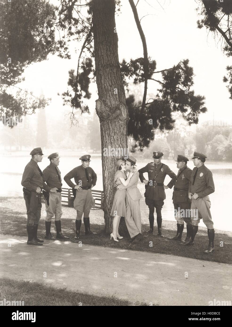 Police officers surrounding romantic couple in park Stock Photo - Alamy