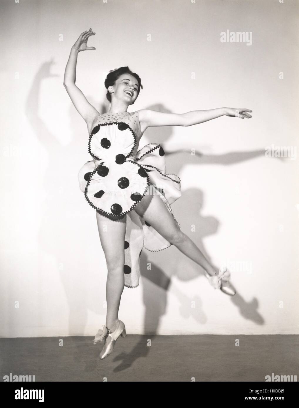 Dancer in polka dot costume leaping in mid air Stock Photo - Alamy