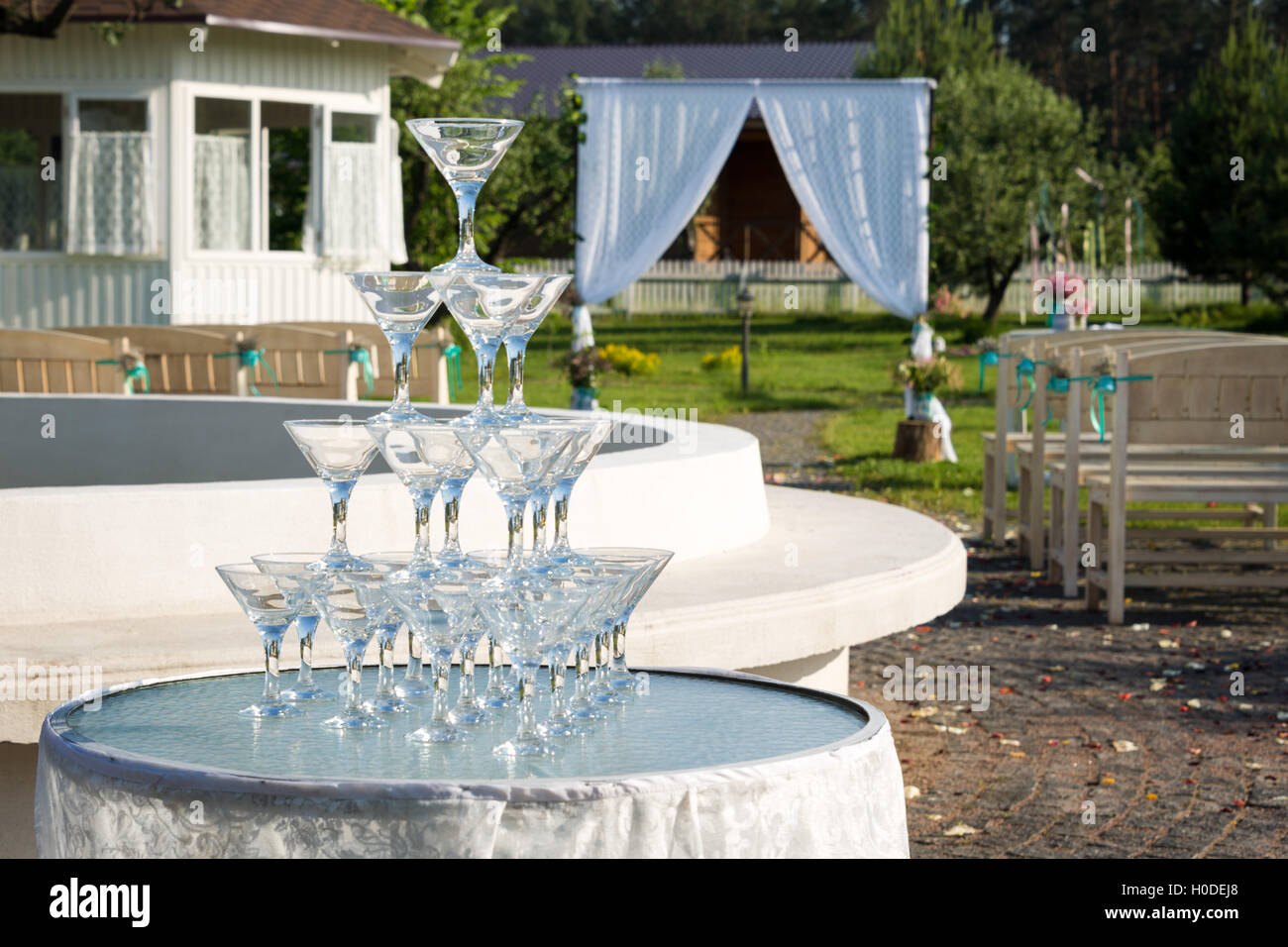 Pyramid of glasses for champagne at outdoor garden in wedding ceremony ...