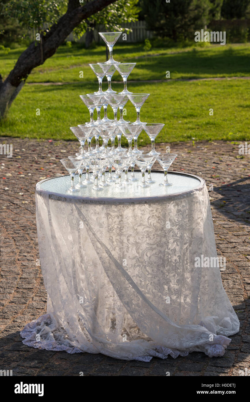 Pyramid of glasses for champagne at outdoor garden in wedding ceremony ...