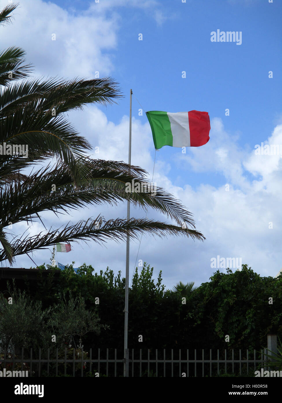 Italian flag flying, blue sky background Stock Photo - Alamy