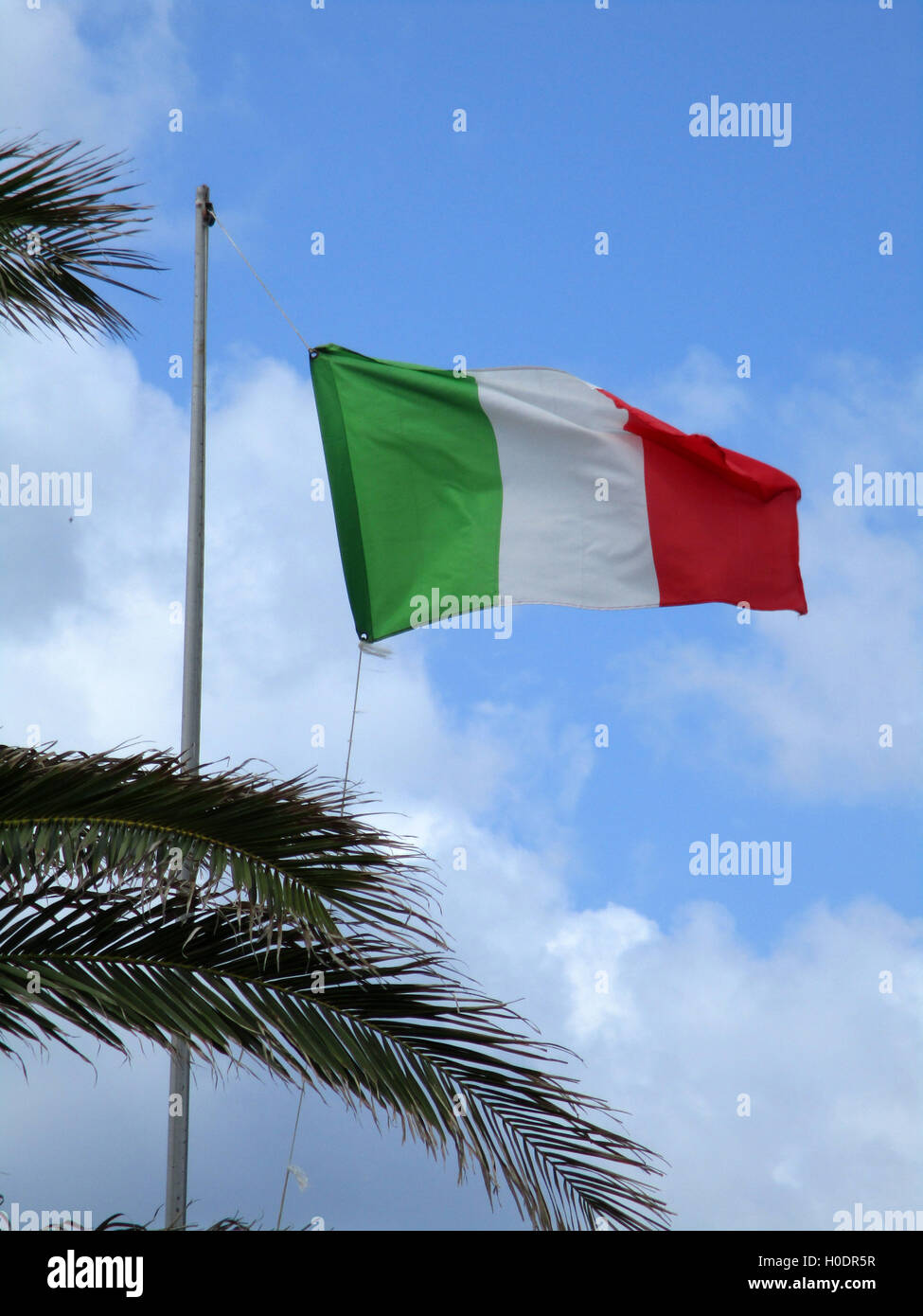 Italian flag flying, blue sky background Stock Photo - Alamy
