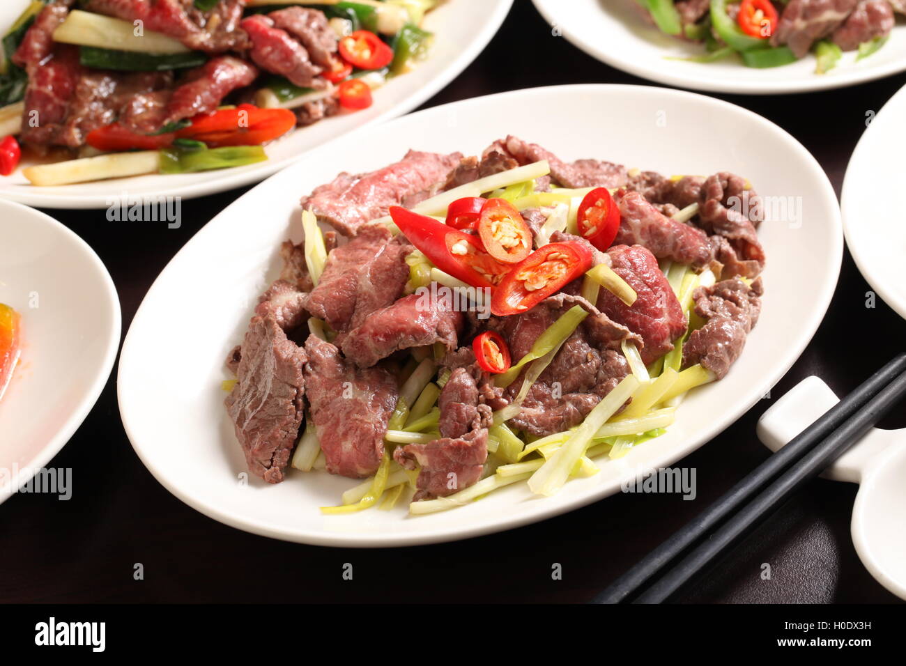 Chive fried beef with chili and onion on white plate in restaurant ...