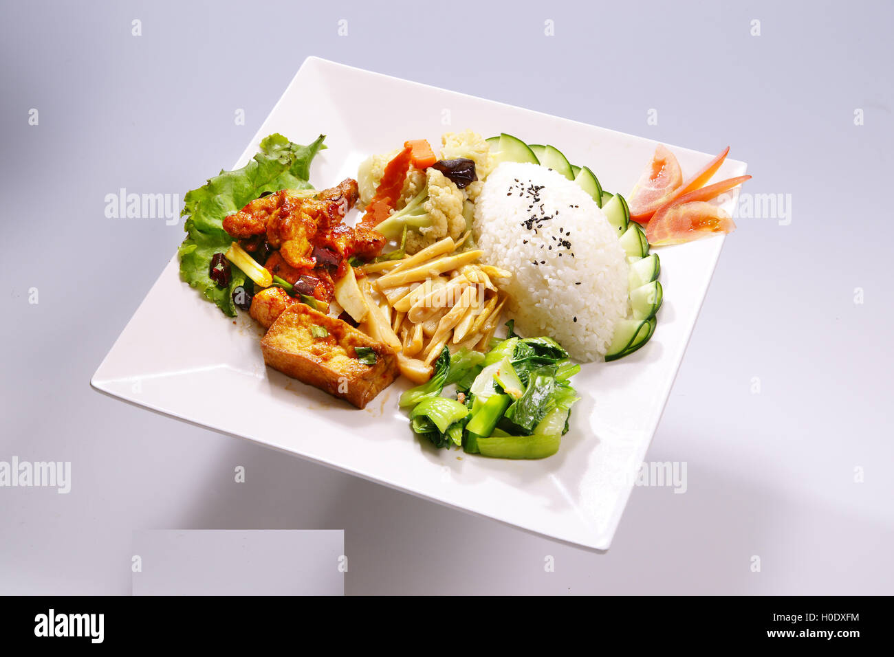 Fragrant fried fish row, Kung Pao Chicken with vegetable on white plate ...