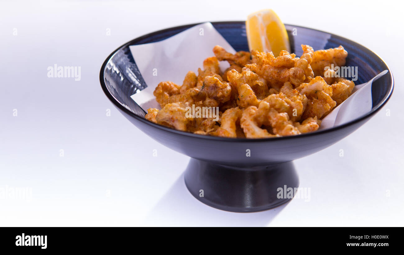 Fried ring octopus with lemon in blue chinese bowl on white background ...