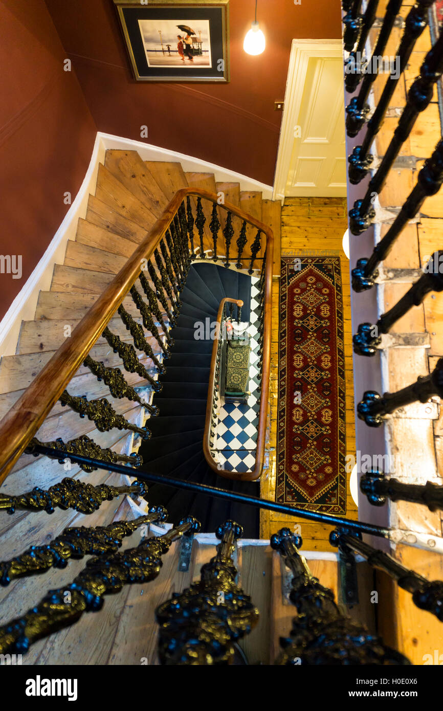 A vertiginous view down the staircase from the top floor of a tall old ...
