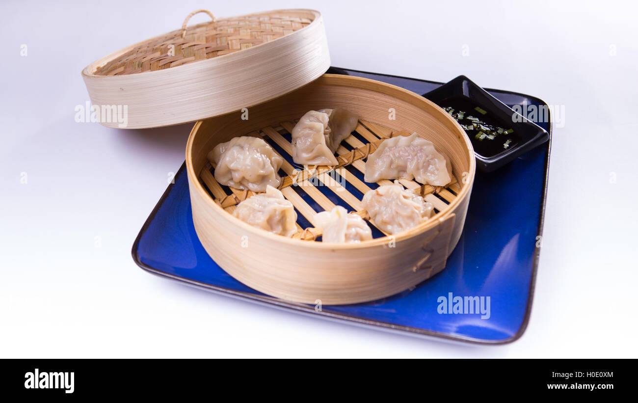 Gyoza or Japanese dumplings in blue chinese bamboo tray on white ...