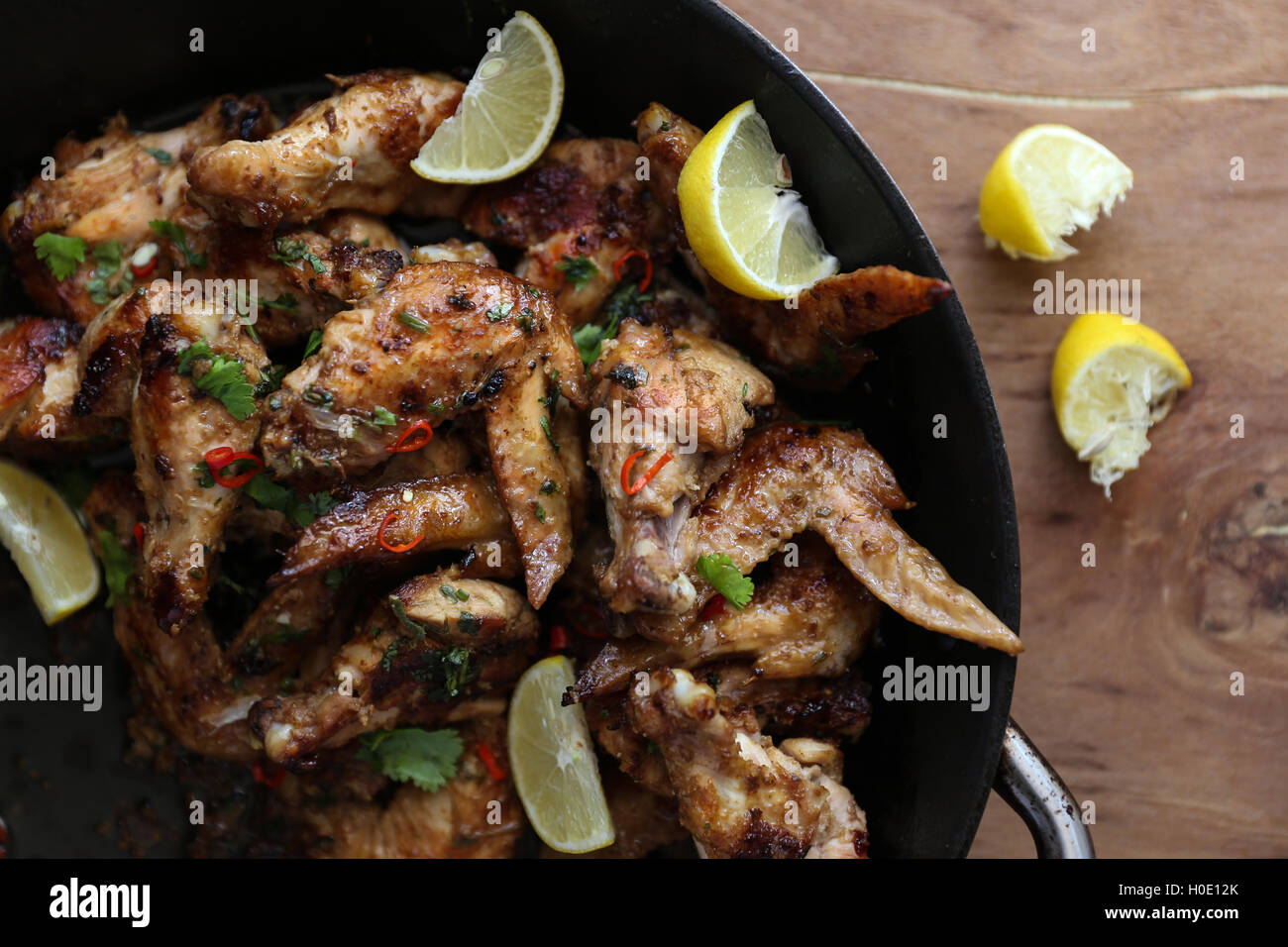Sand ginger of fried chicken with lemon in black pan on wooden table ...