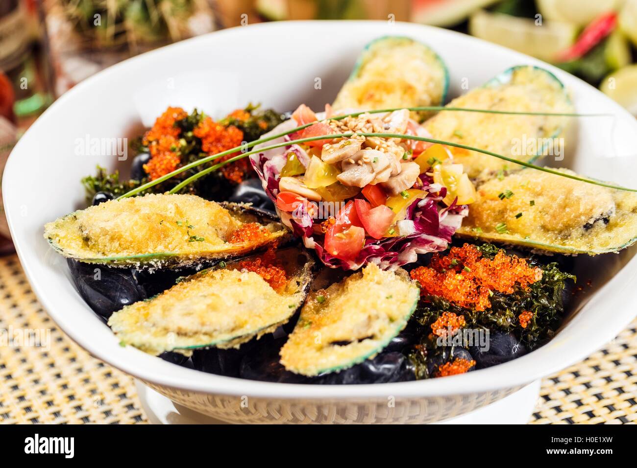 Fried breaded clams with salad and caviar on white bowl Stock Photo - Alamy