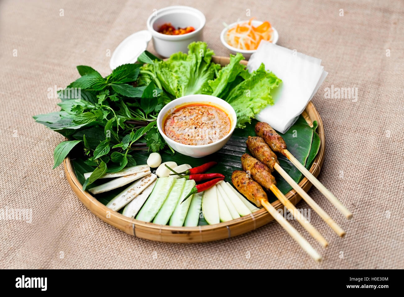 Vietnamese fermented pork roll or nem Hue with lettuce, herbs and chili ...