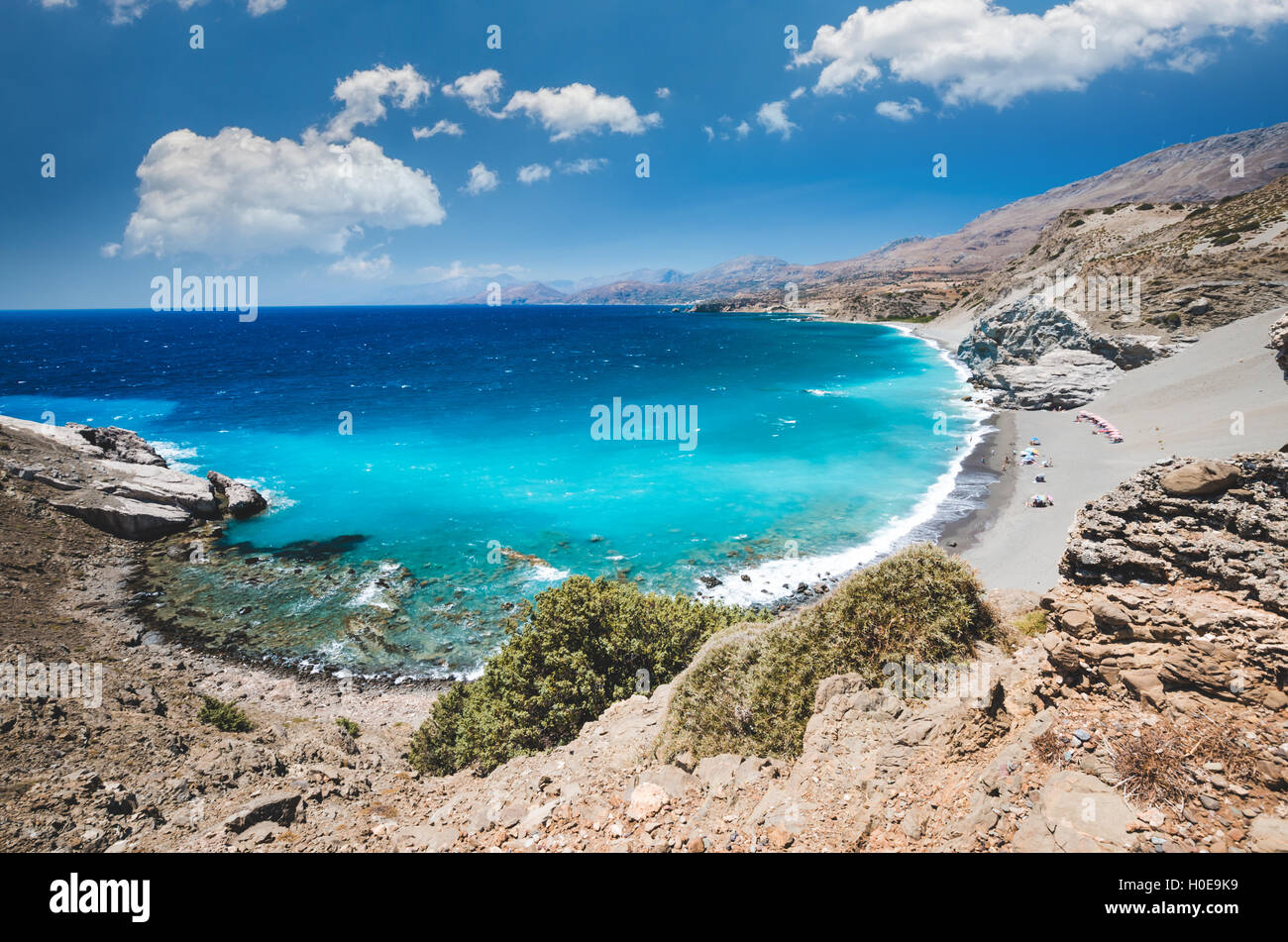 Agios Pavlos Beach in Crete island, Greece. Tourists relax and bath in crystal clear water of St ...