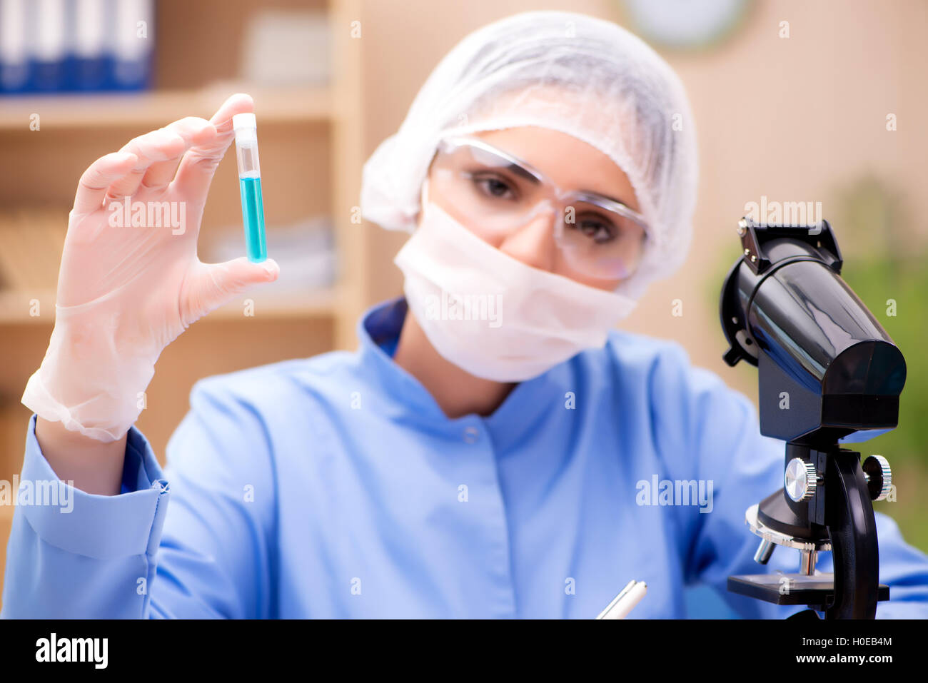 Lab chemist working with microscope and tubes Stock Photo - Alamy