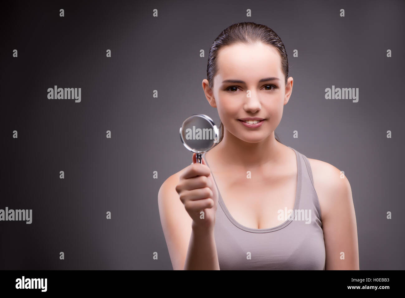 Woman with magnifying glass in sports concept Stock Photo - Alamy