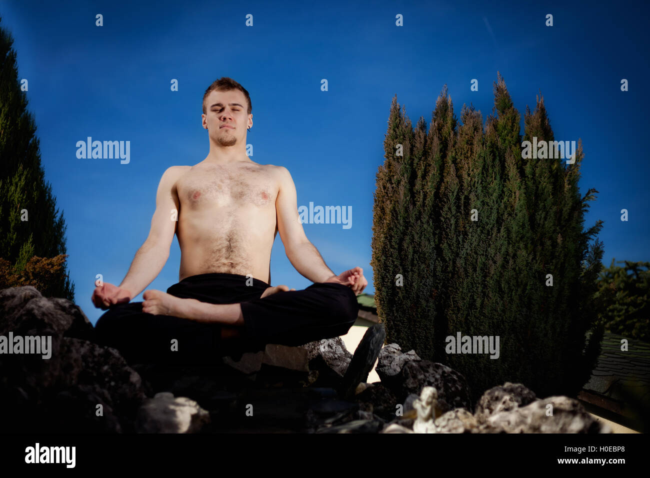 Outdoor yoga session in beautiful garden - young man meditating Stock ...