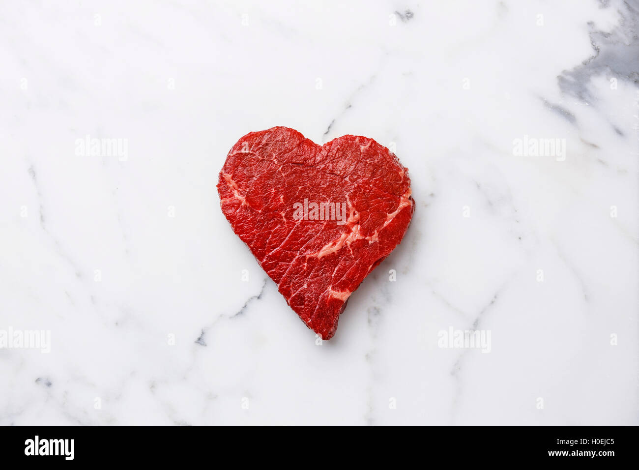 Heart shape Raw fresh meat on white marble background Stock Photo - Alamy