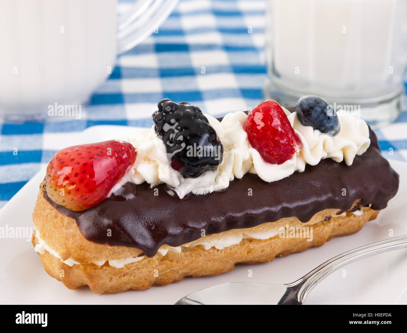 Chocolate eclair with berries and whipped cream on top Stock Photo - Alamy