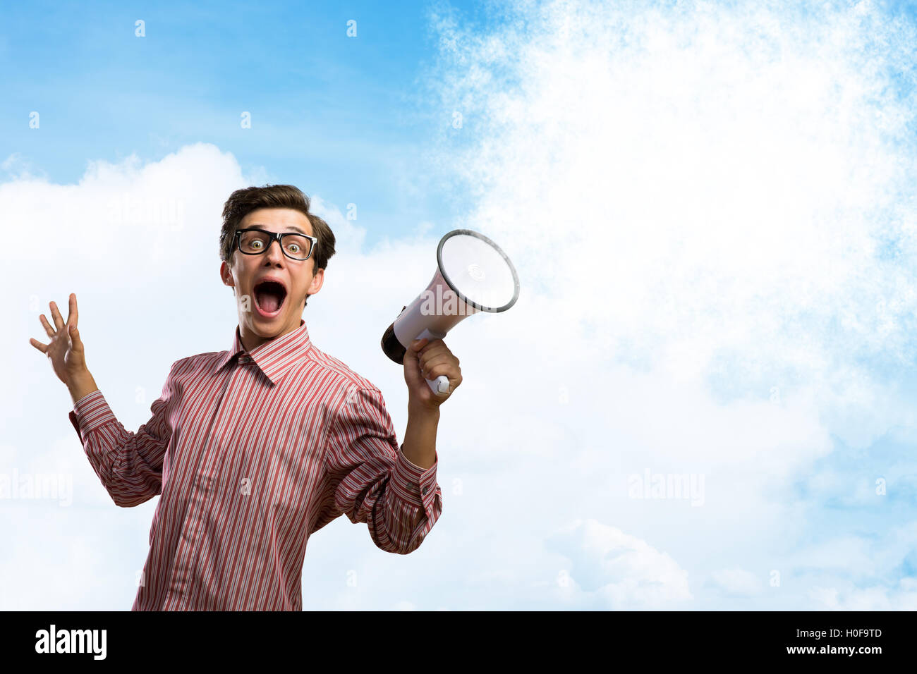 Portrait of a young man shouting using megaphone Stock Photo - Alamy