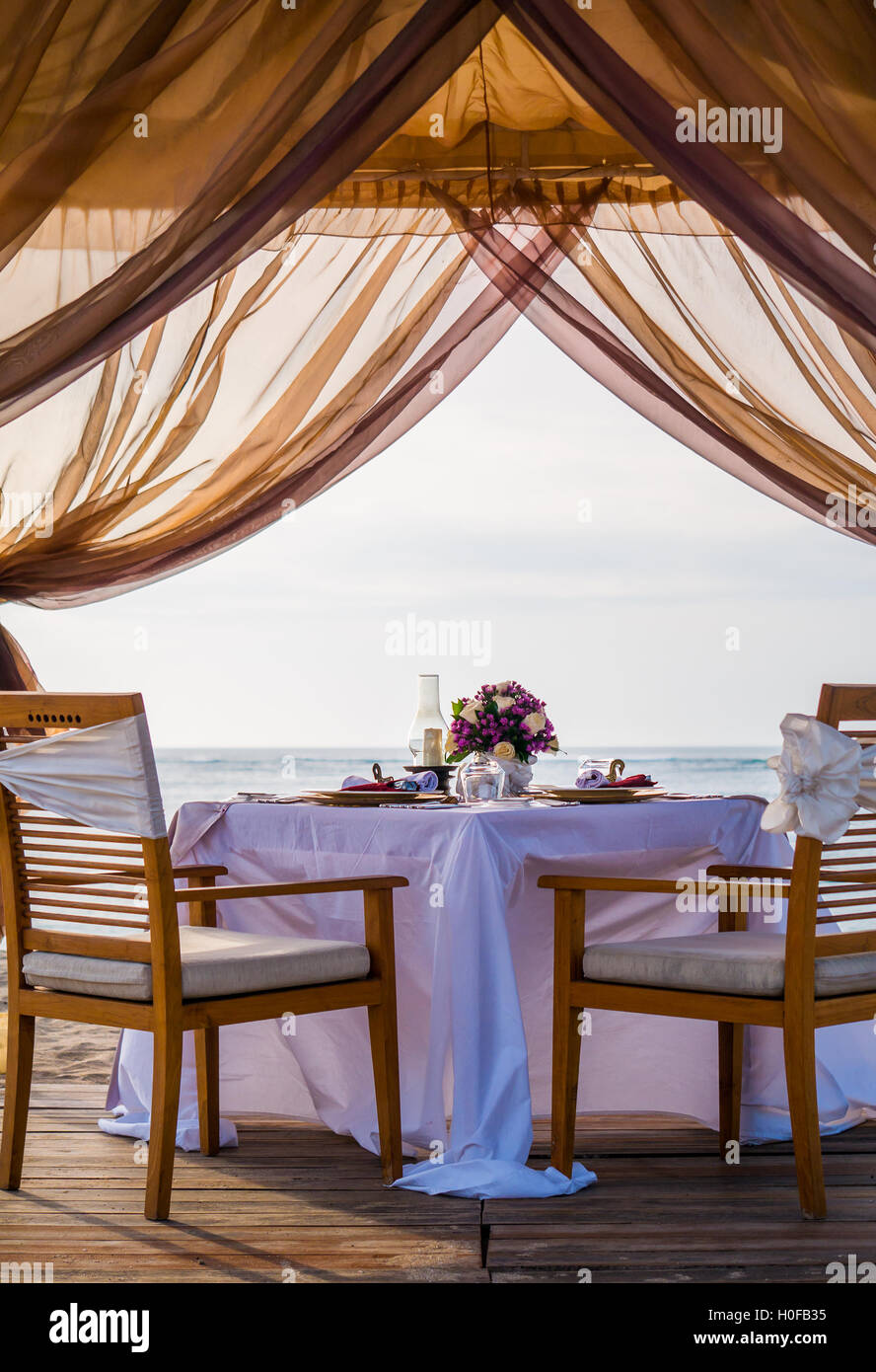 Romantic dinner table set on the beach Stock Photo - Alamy