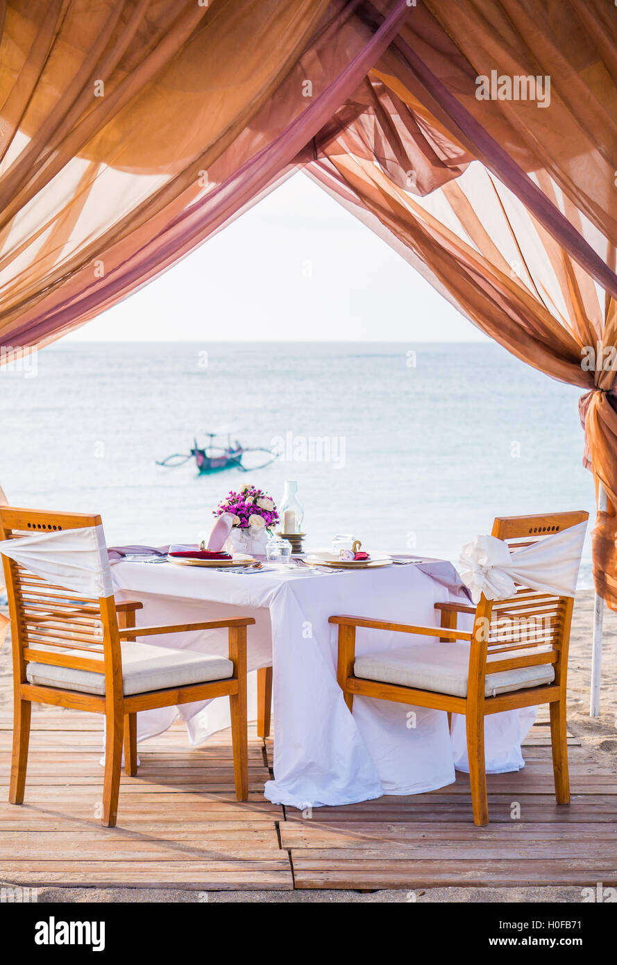Romantic dinner table set on the beach Stock Photo - Alamy