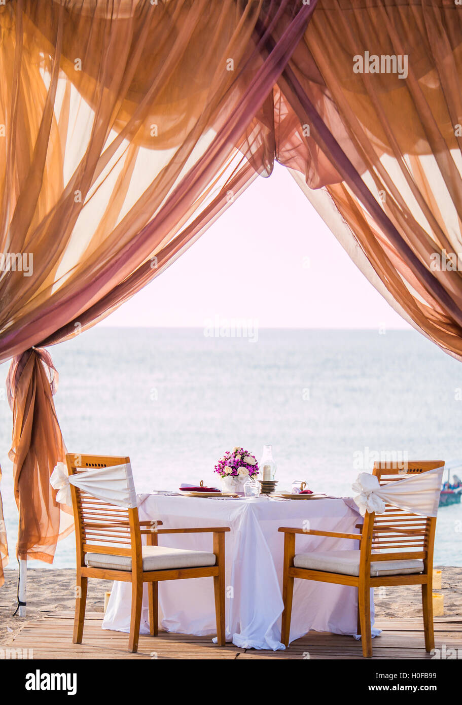 Romantic dinner table set on the beach Stock Photo - Alamy