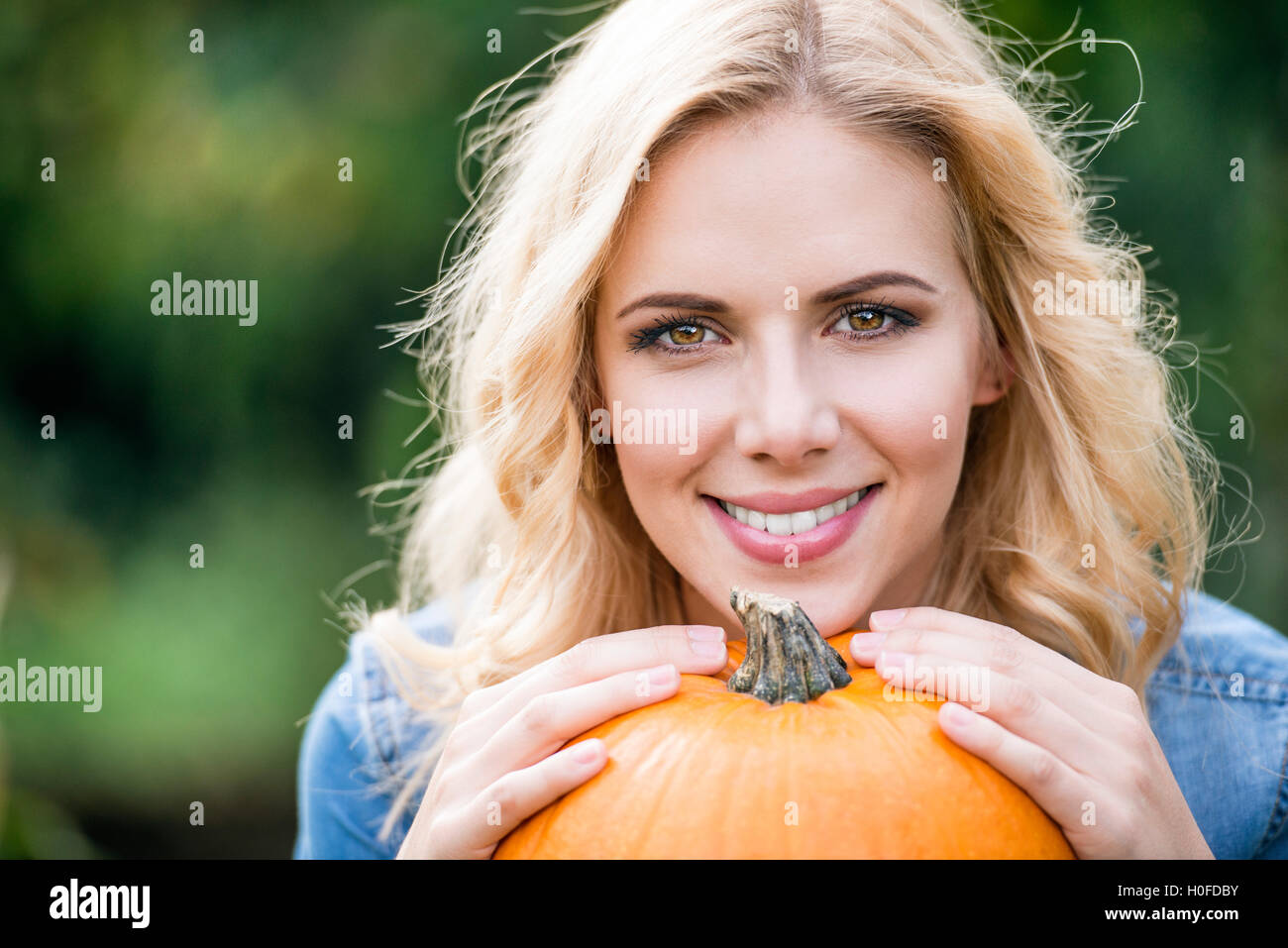 Close up, Beautiful young blond woman holding orange pumpkin Stock ... Close up, Beautiful young blond woman holding orange pumpkin Stock ...