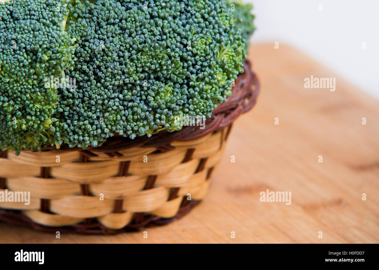 close up on Fresh broccoli solated in basket on wood and white ...