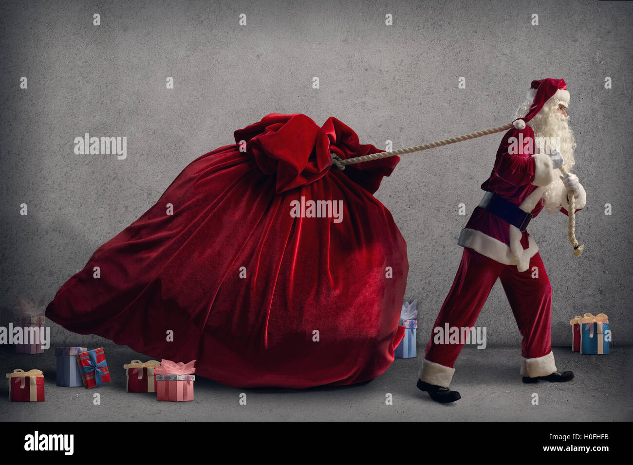 Santa Claus pulls a huge bag of gifts Stock Photo - Alamy
