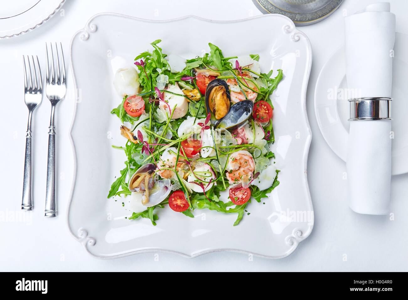 Seafood salad with clams, shrimps, squid, lettuce, tomatoes and herbs ...