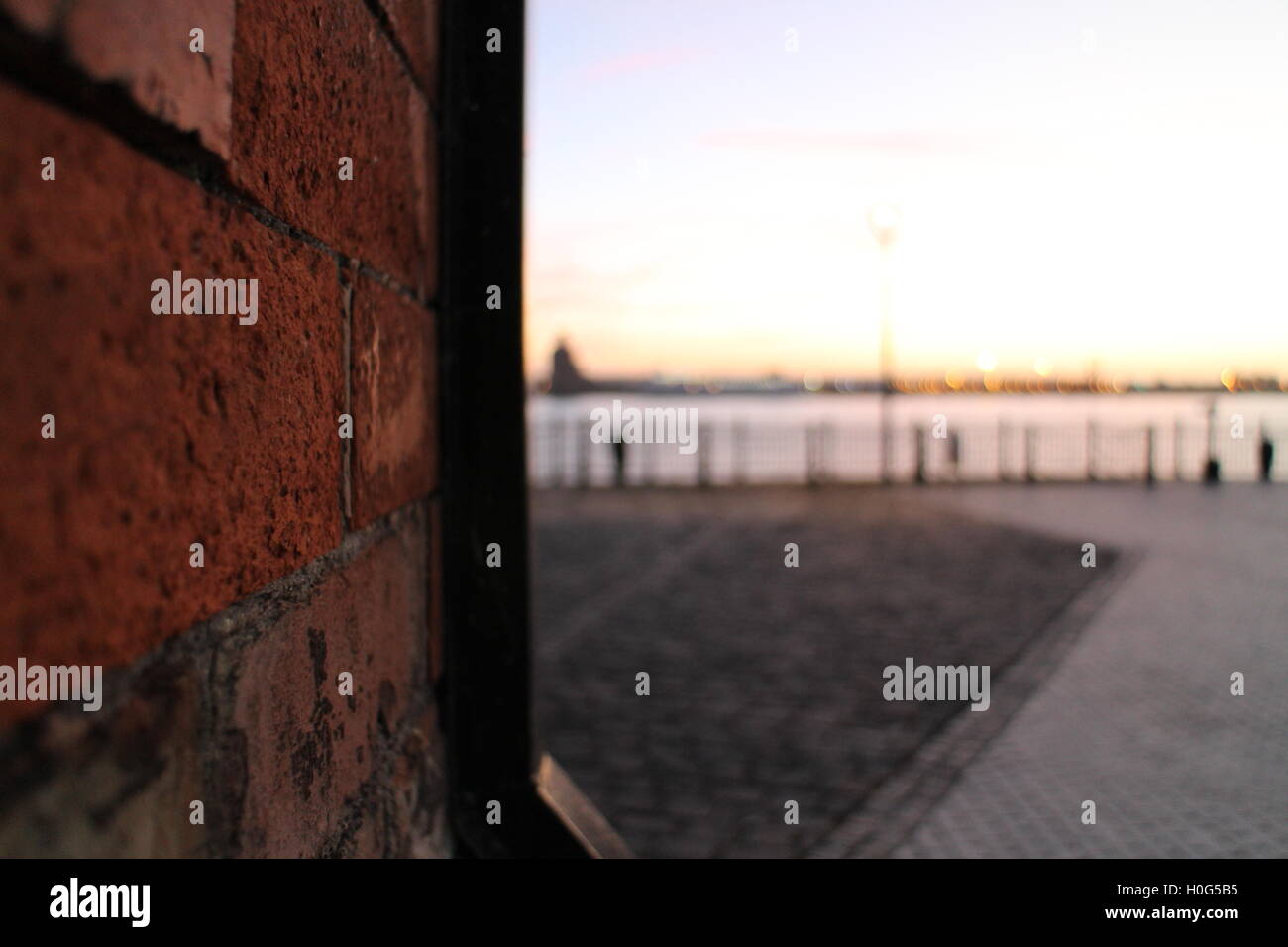 Photo depicting a brick wall with the River Mersey in the background ...