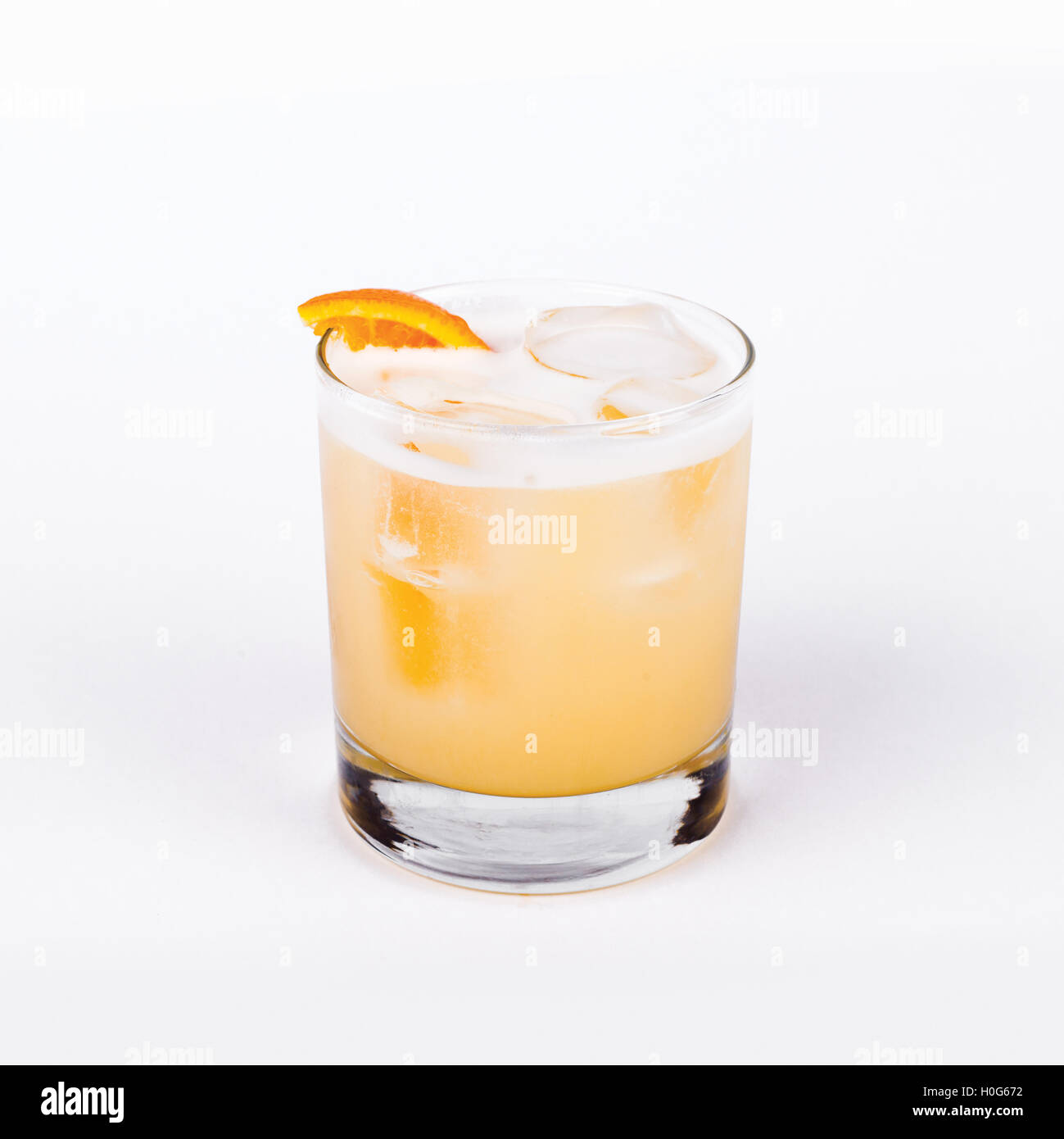 Glass of Whiskey sour with orange in white background Stock Photo - Alamy