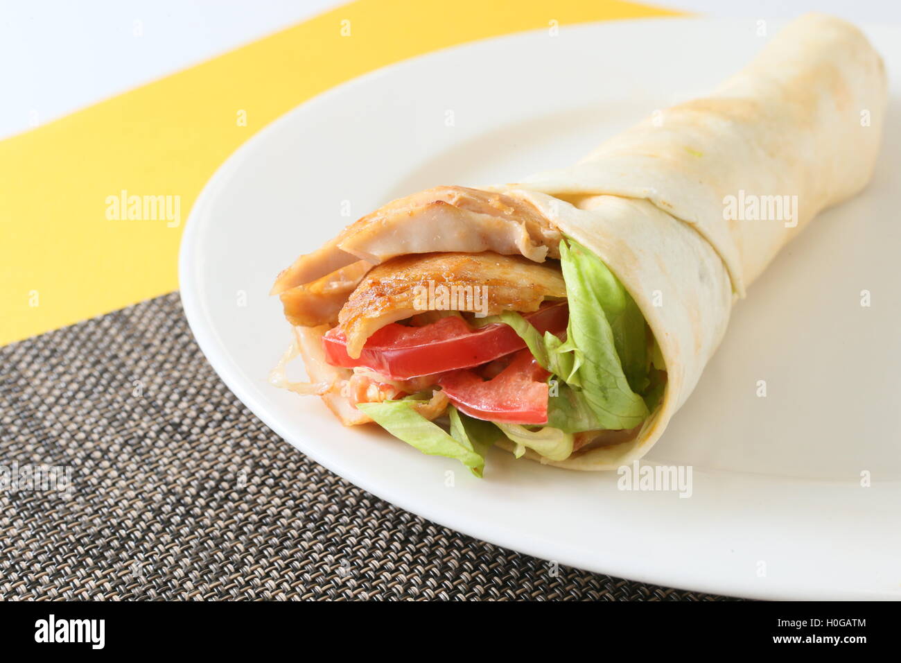 The kebab wrap roll with tomatoes and lettuce on white platter Stock ...