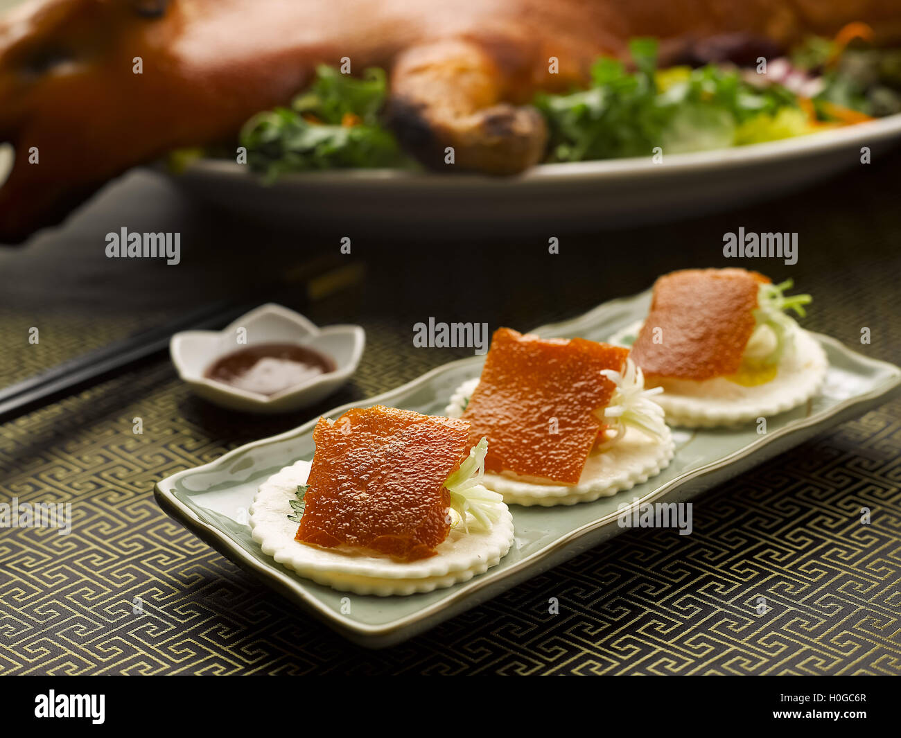 Roasted Suckling Pig skin with onion and crackers on dish in restaurant ...