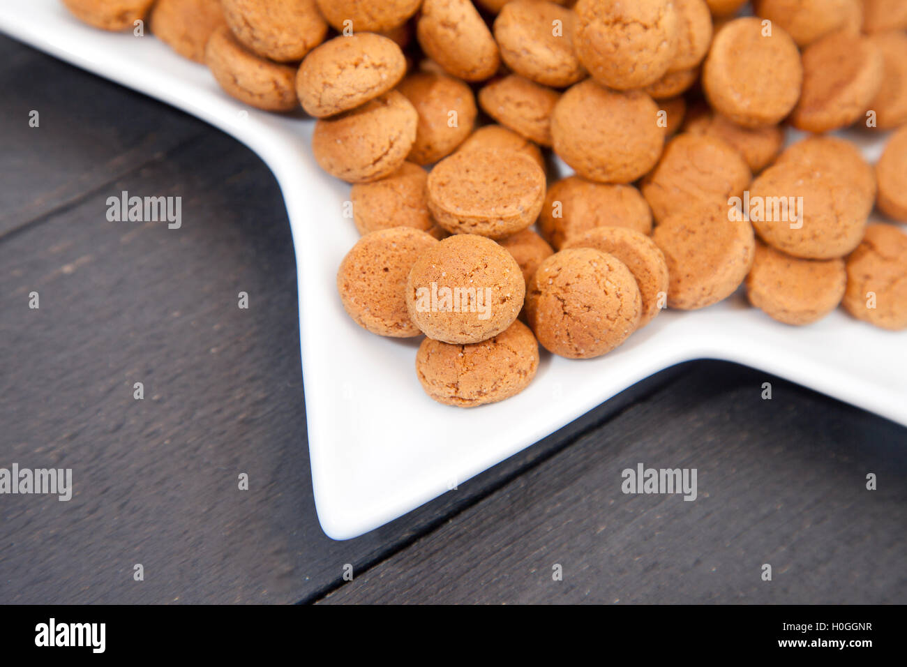 Traditional Dutch candy pepernoot on white plate on white wooden ...