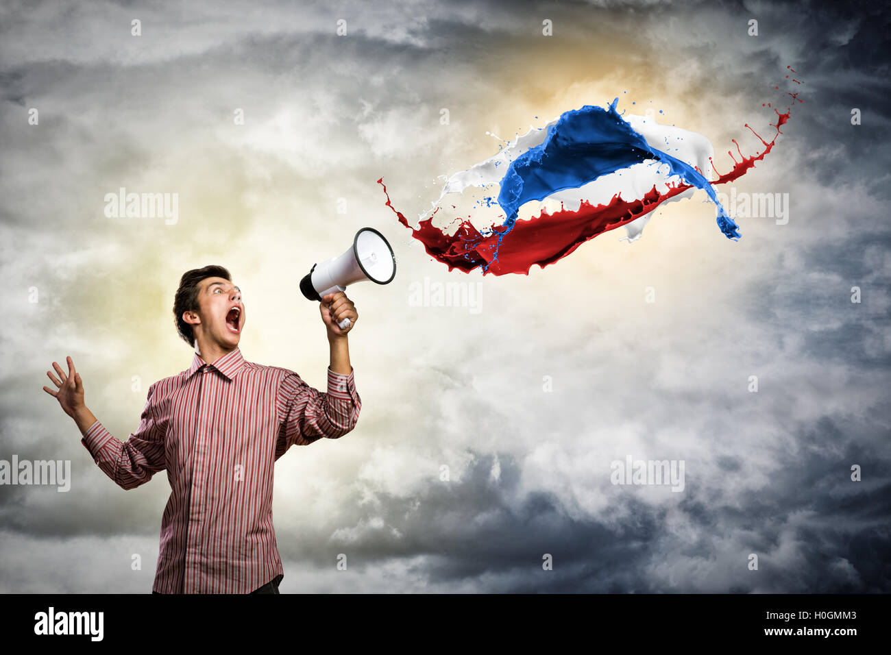 Portrait of a young man shouting using megaphone Stock Photo - Alamy