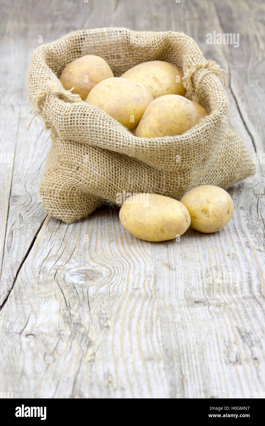 Raw potatoes in burlap bag Stock Photo - Alamy