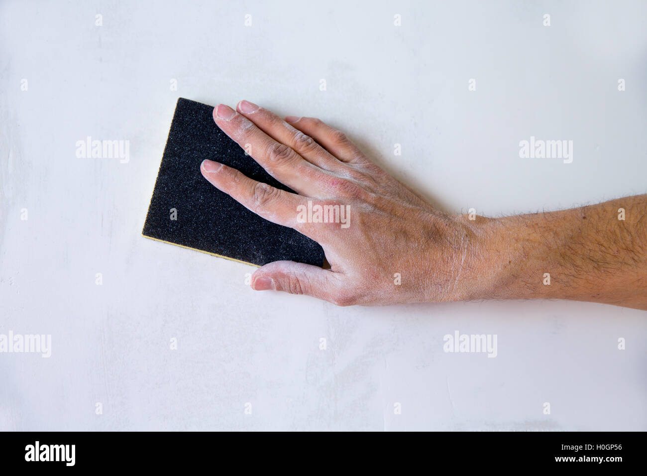 plastering man hand sanding the plaster Stock Photo - Alamy