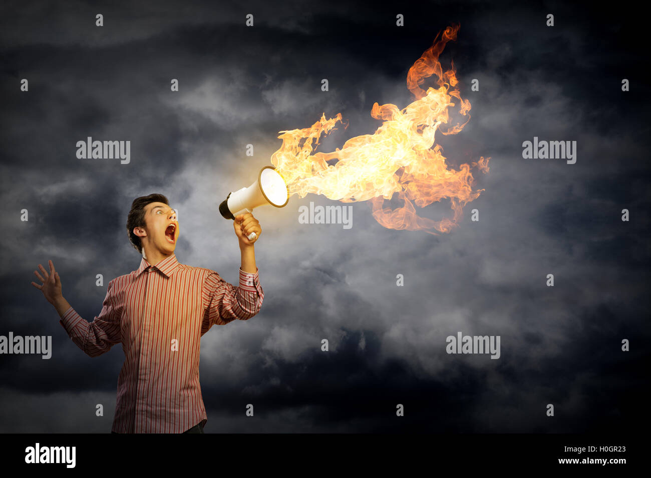 Portrait of a young man shouting using megaphone Stock Photo - Alamy