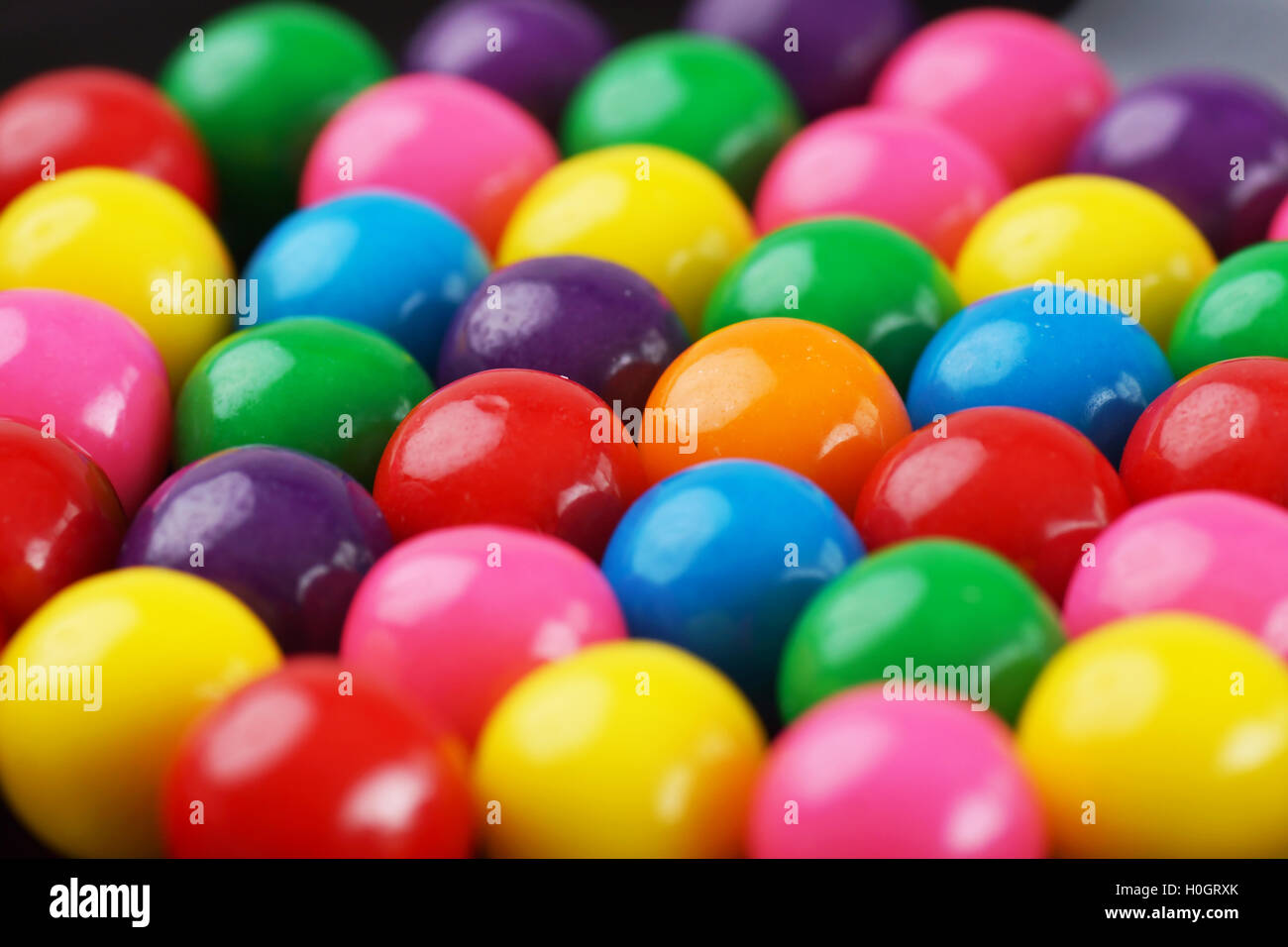 Orange gumball standing out Stock Photo - Alamy