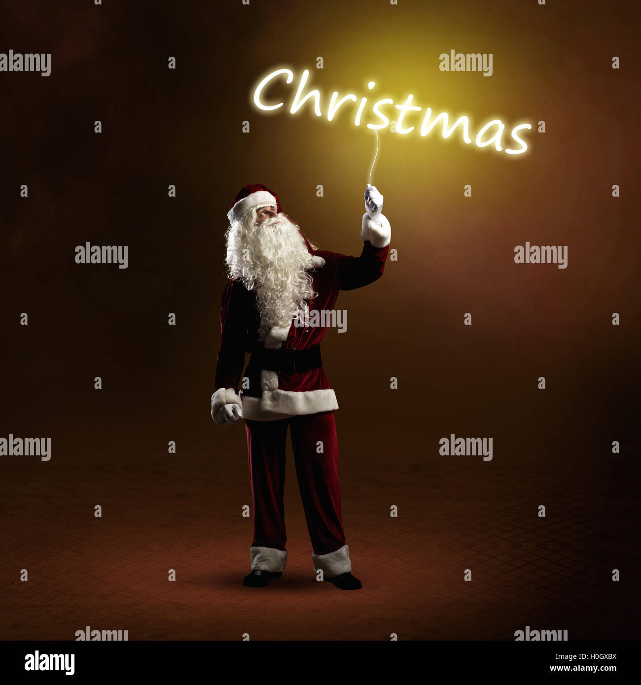 Santa Claus is holding a shining Christmas word Stock Photo - Alamy