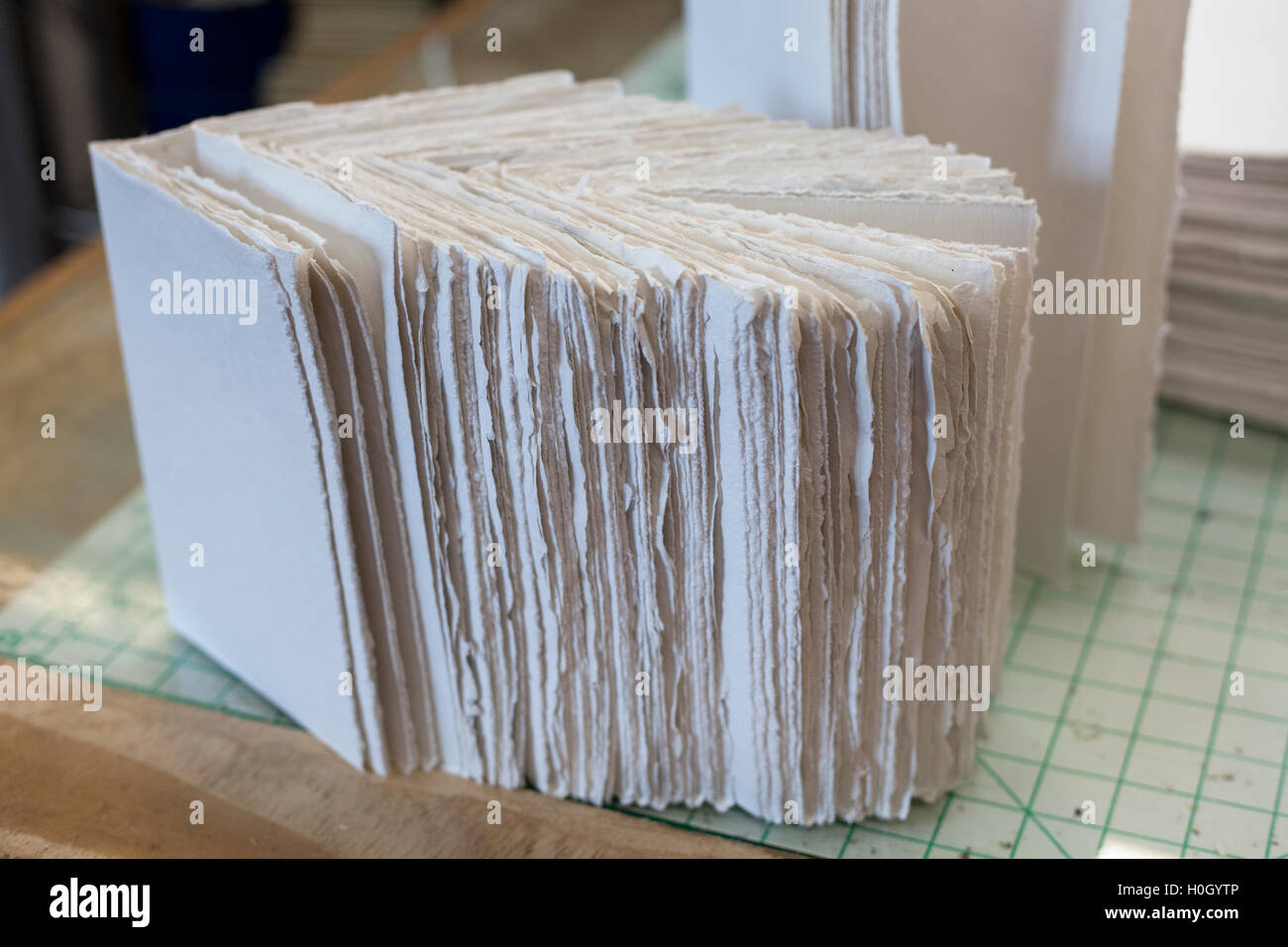 Newly folded paper pages sit at workstation Stock Photo - Alamy