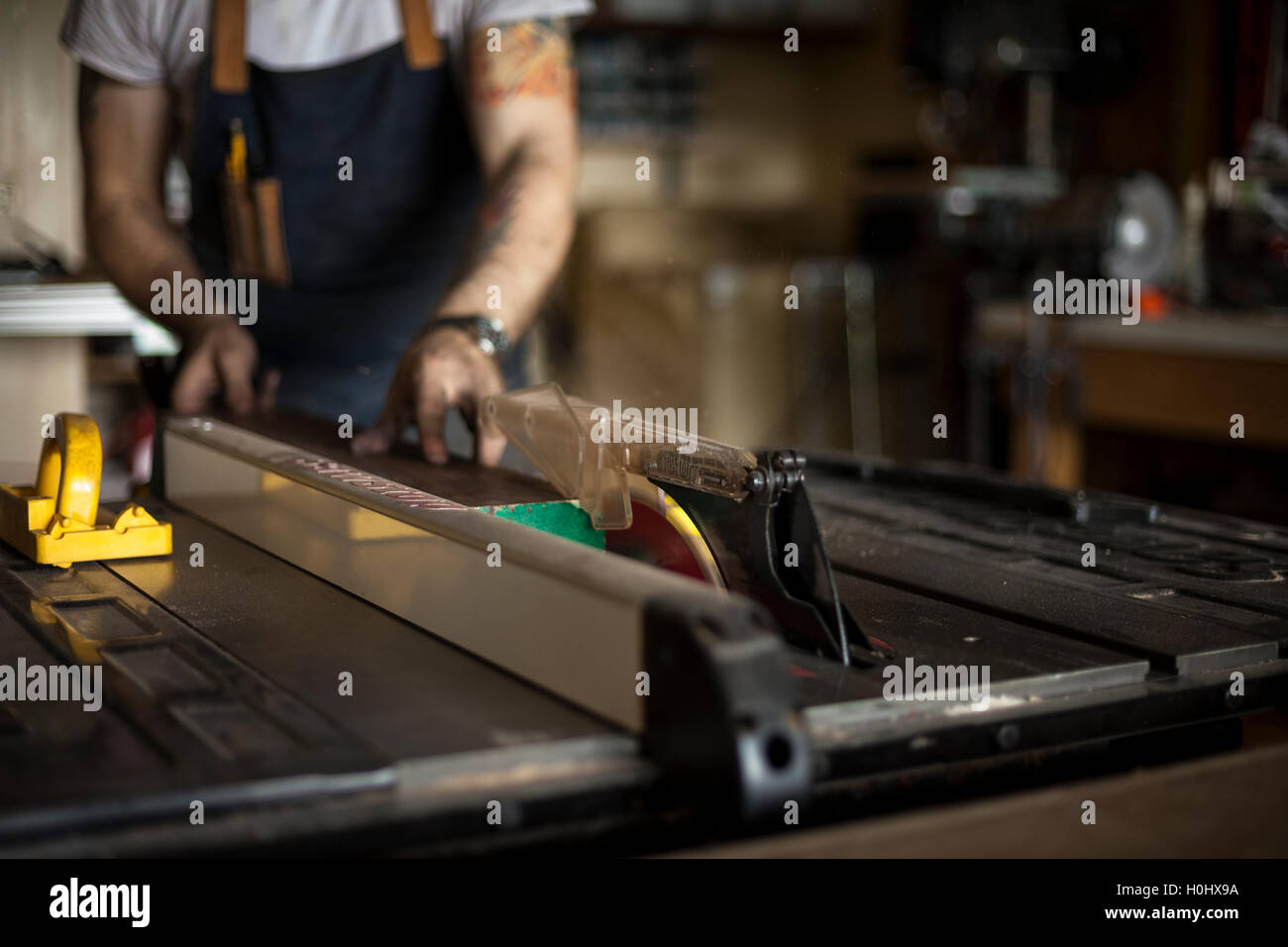 Custom furniture craftsman cuts wood with saw Stock Photo - Alamy