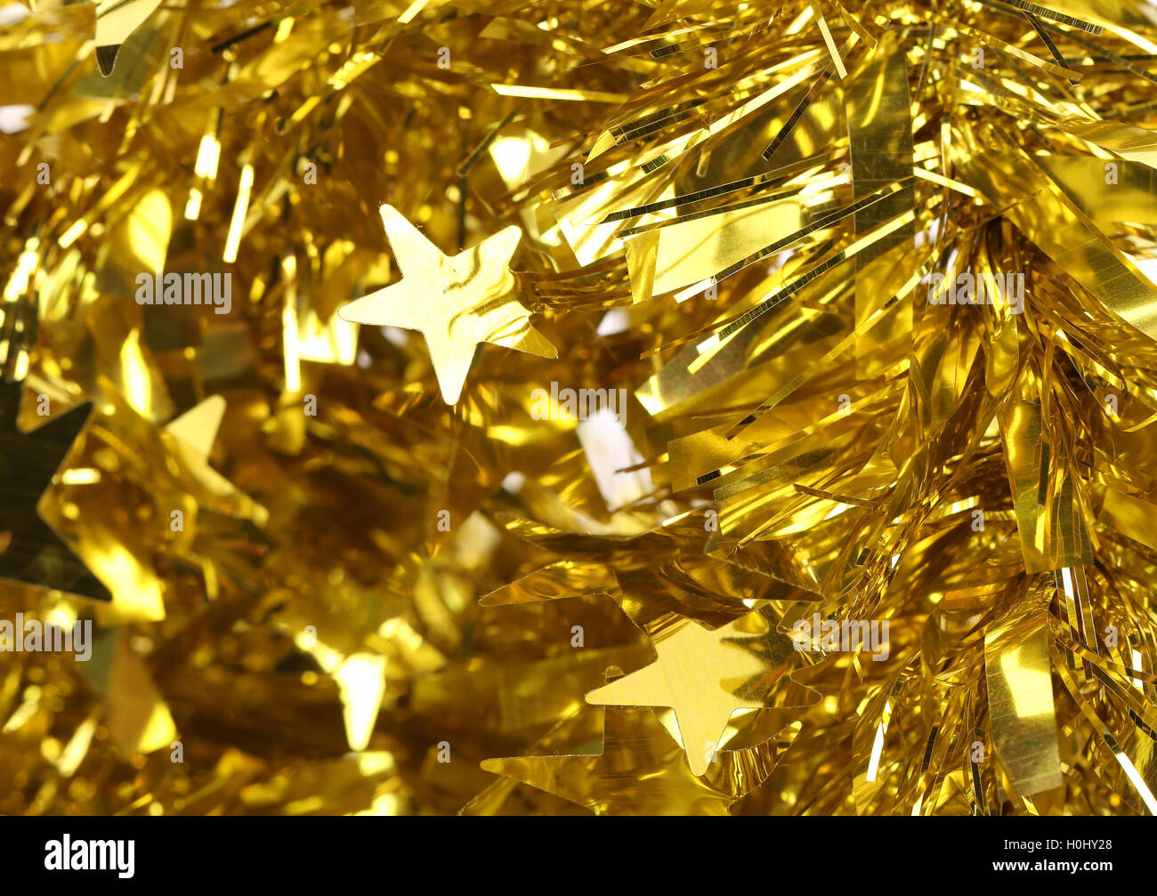 Christmas golden tinsel with stars Stock Photo - Alamy