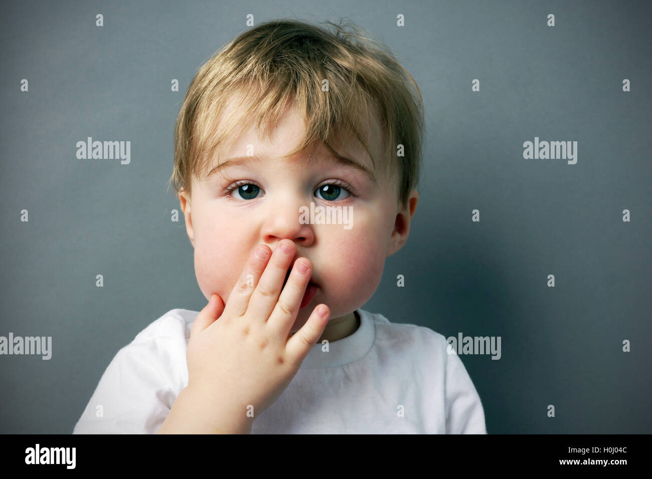 Blond boy with pardon me face Stock Photo - Alamy