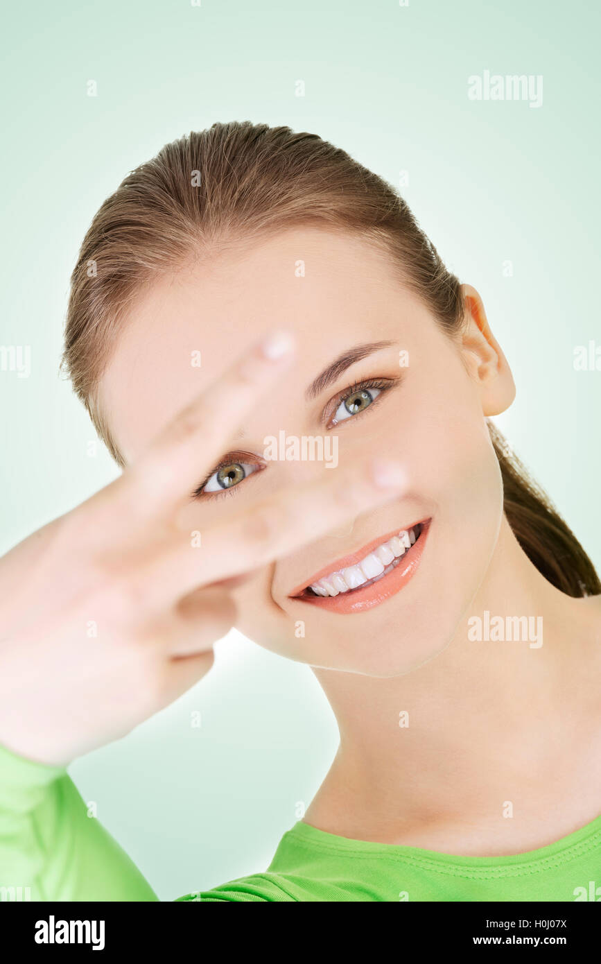 Happy teenager girl showing victory sign Stock Photo - Alamy