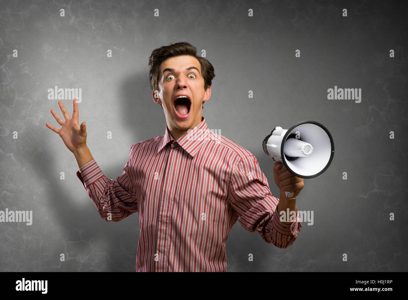 Portrait of a young man shouting using megaphone Stock Photo - Alamy