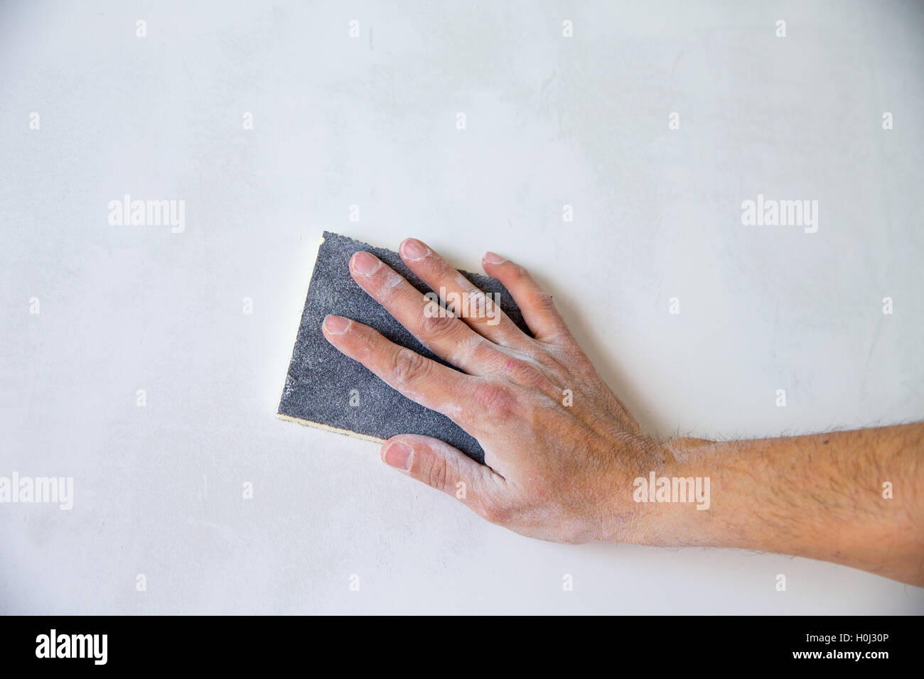 plastering man hand sanding the plaster Stock Photo - Alamy