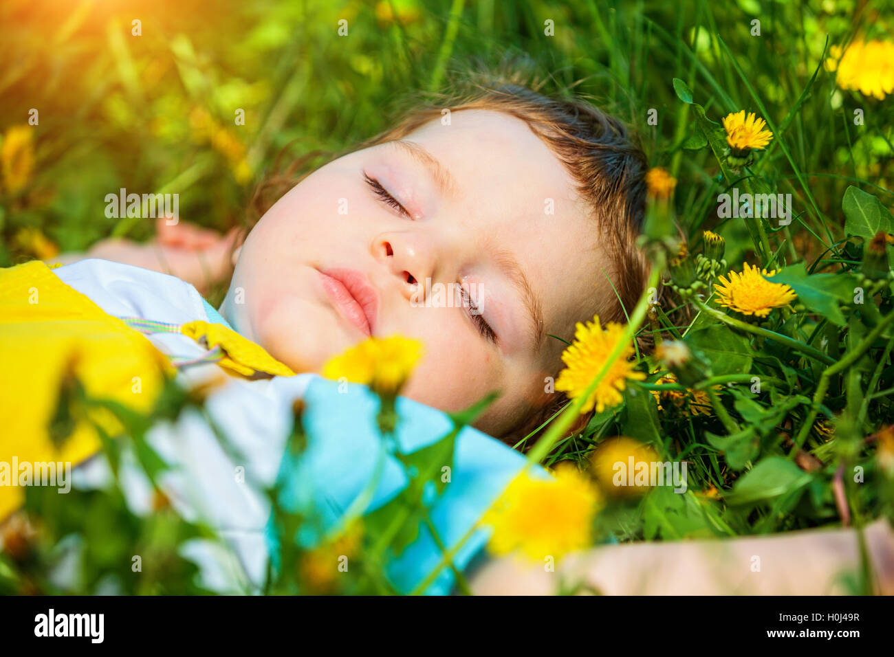 Sleeping boy on grass Stock Photo - Alamy
