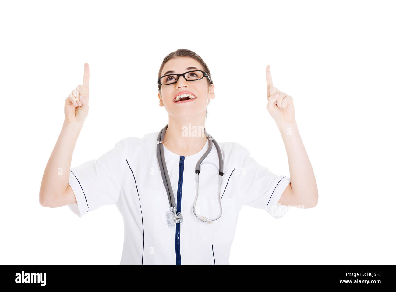 Beautiful young woman doctor pointing up Stock Photo - Alamy