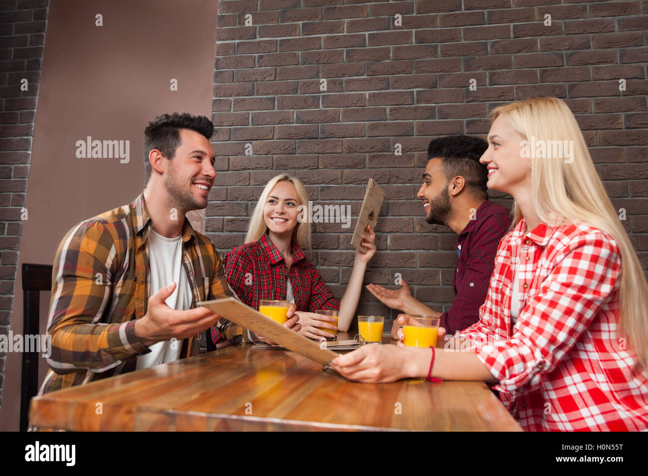 Young People Group Sit At Table Bar Hold Menu, Making Order, Mix Race ...